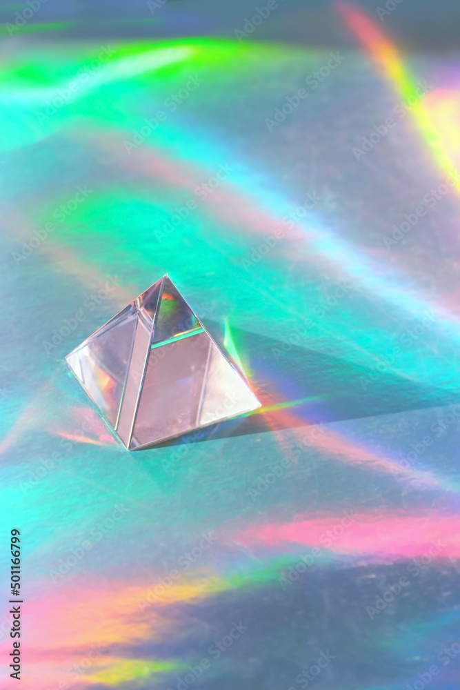 quartz crystal pyramid (triangle) on holographic background. Refracting ...