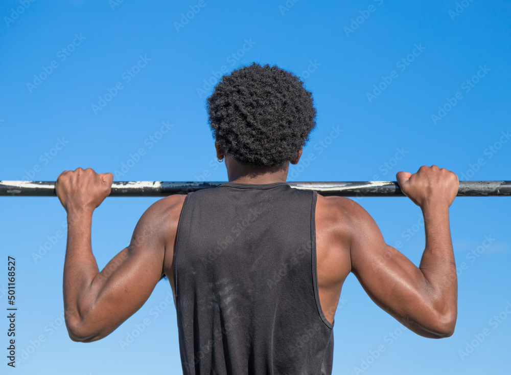 Strong guy doing pull up in a calisthenics park. Outdoor training and ...