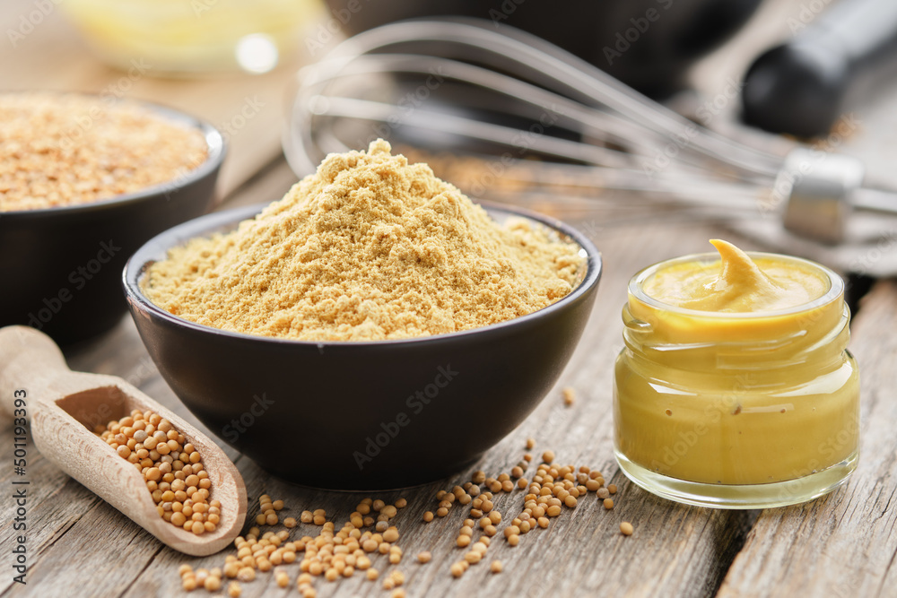 Mustard sauce jar and bowl of powdered mustard seeds. Scoop of whole ...