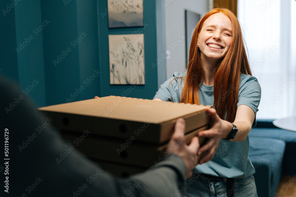 Happy excited young woman receiving carton boxes with pizza from ...