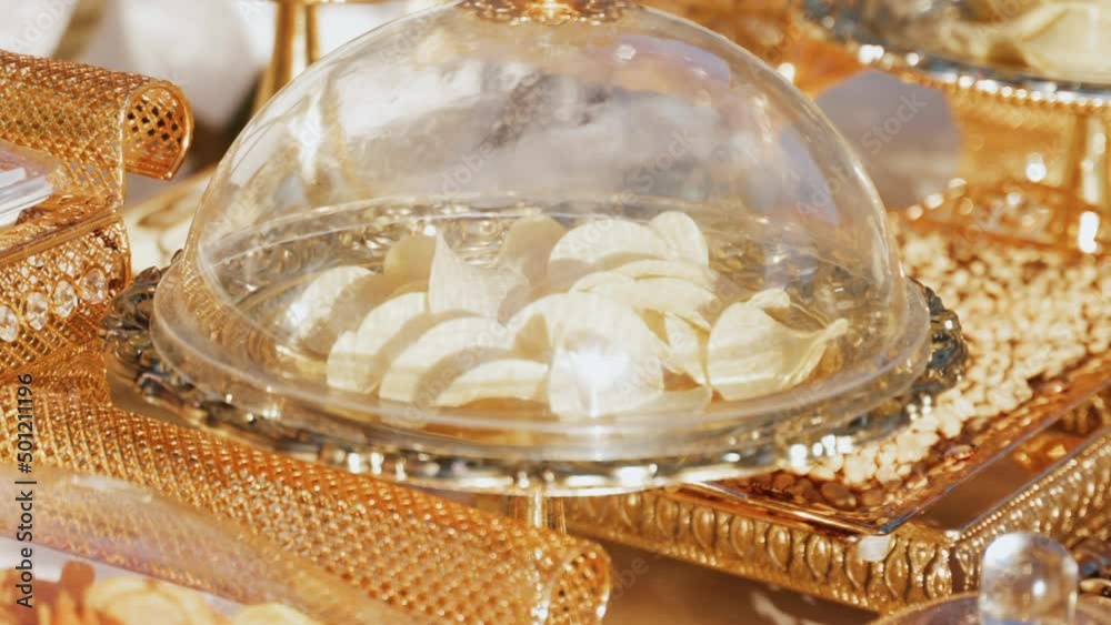 Crispy chips and peeled nuts stand on exquisite gold stands. Buffet ...
