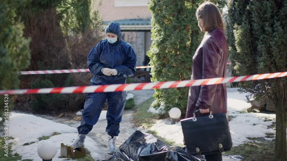 Portrait of forensics scientist in uniform and face mask talking with ...