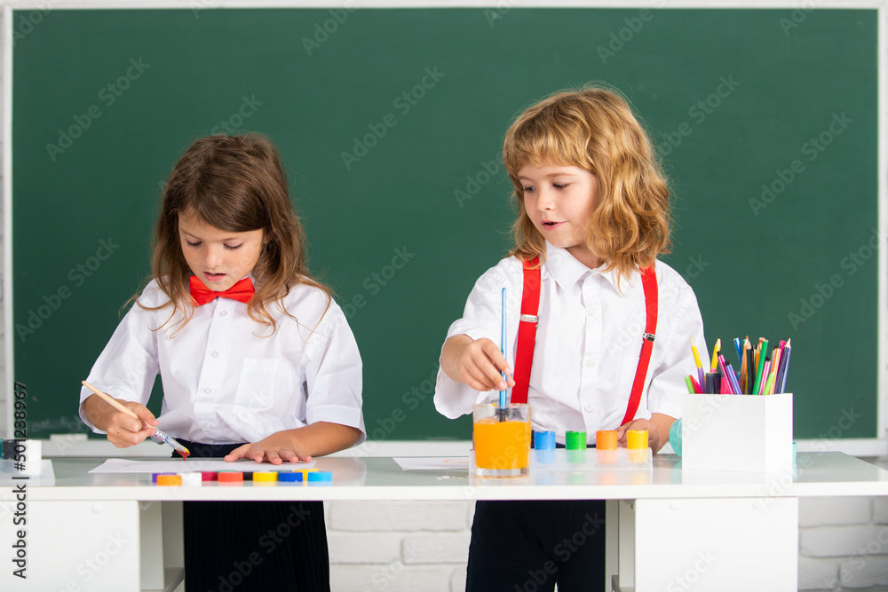 School children drawing a colorful pictures with pencil crayons in ...