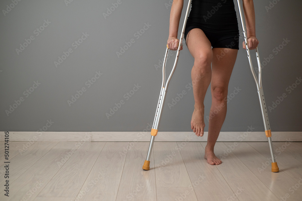 Disabled woman walking with crutches and sprained ankle Stock Photo ...
