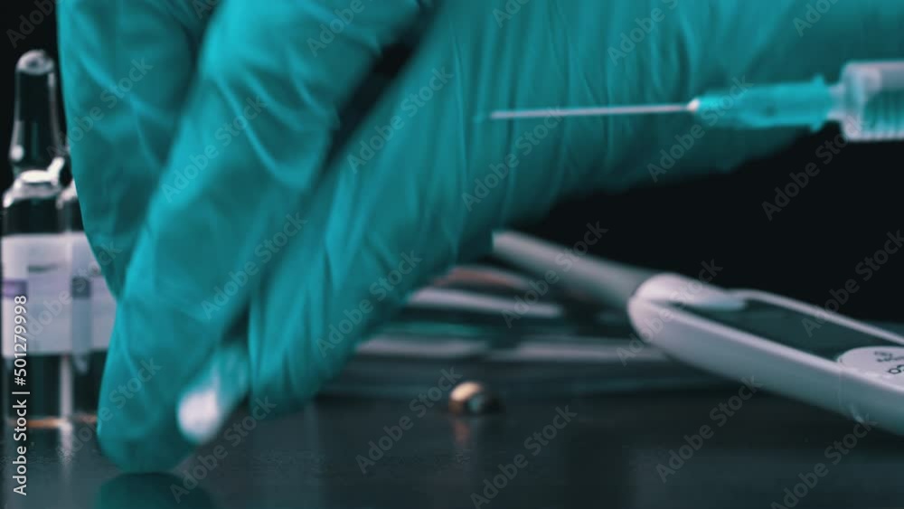 Nurse prepares a syringe and medicine drips from it in large drops ...