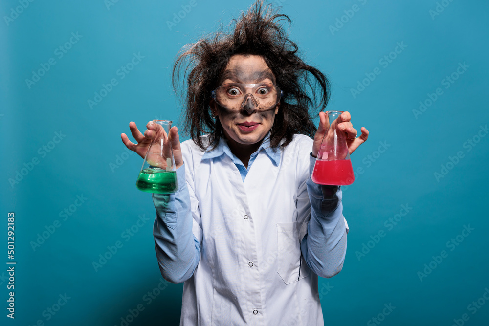 Crazy chemist holding glass flasks filled with toxic chemical compounds ...