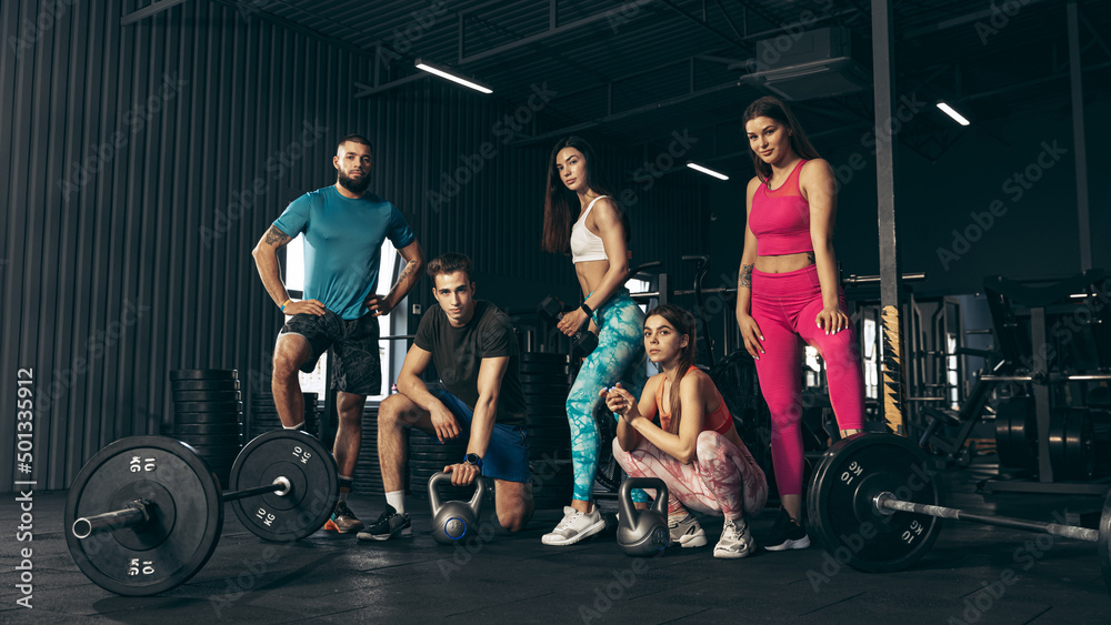 Group of young friends doing sports, training at gym indoors. Friends ...