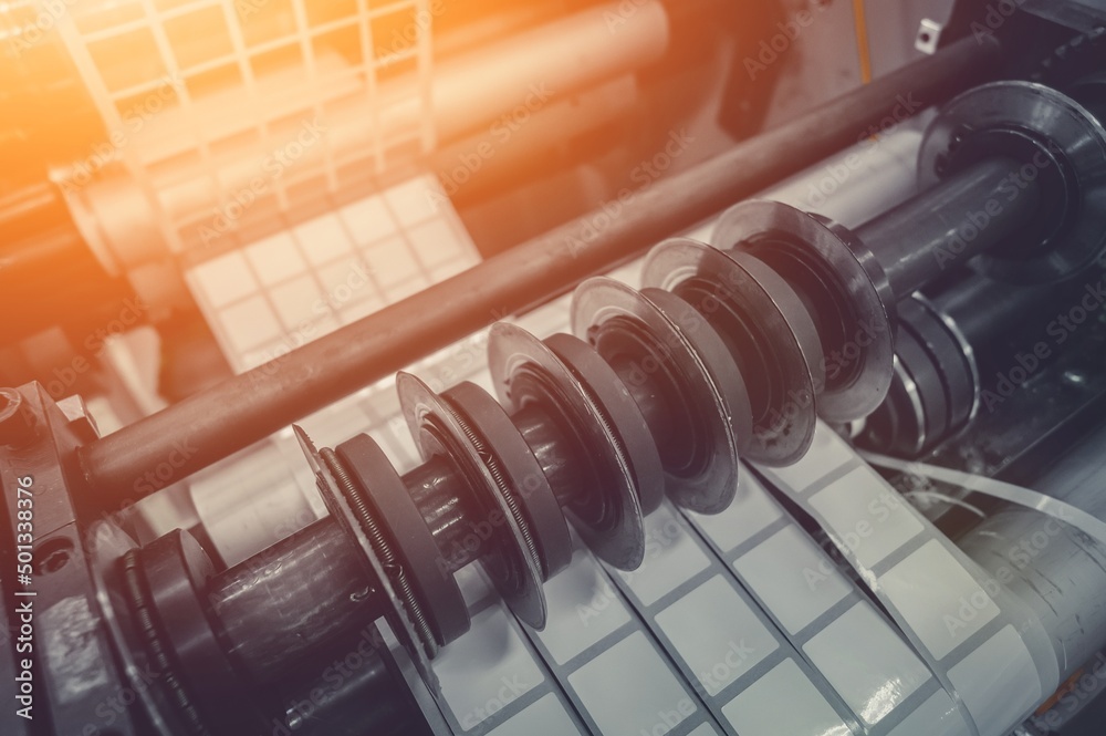 Rotating knives for cutting a self-adhesive label into several narrow ...