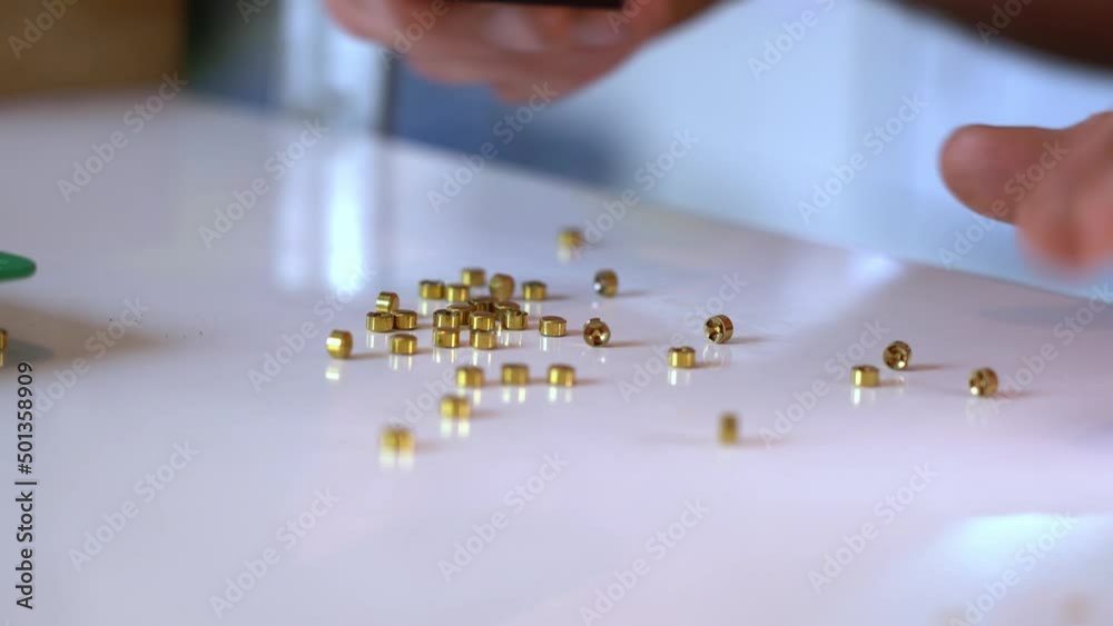 Rifle cartridge primers emptied from tray and landing on white surface ...