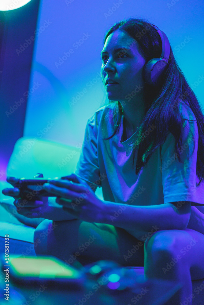 involved gamer girl playing video games on the console on the couch ...