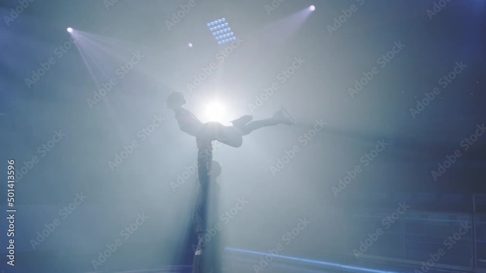 Figure skaters pair on ice rink performing overhead lift,man holds ...
