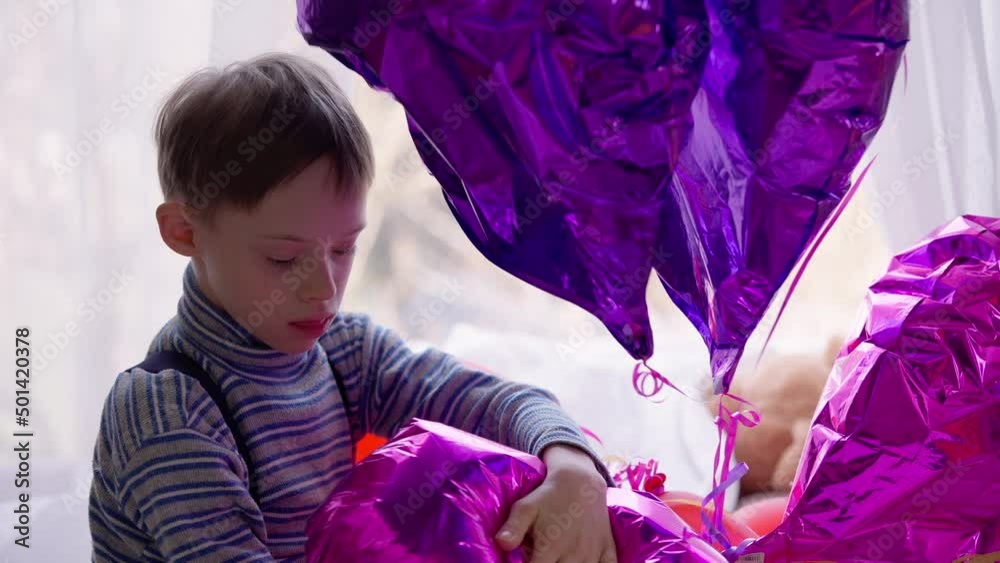 Vidéo Stock Fascinated autistic Caucasian boy playing with deflated ...