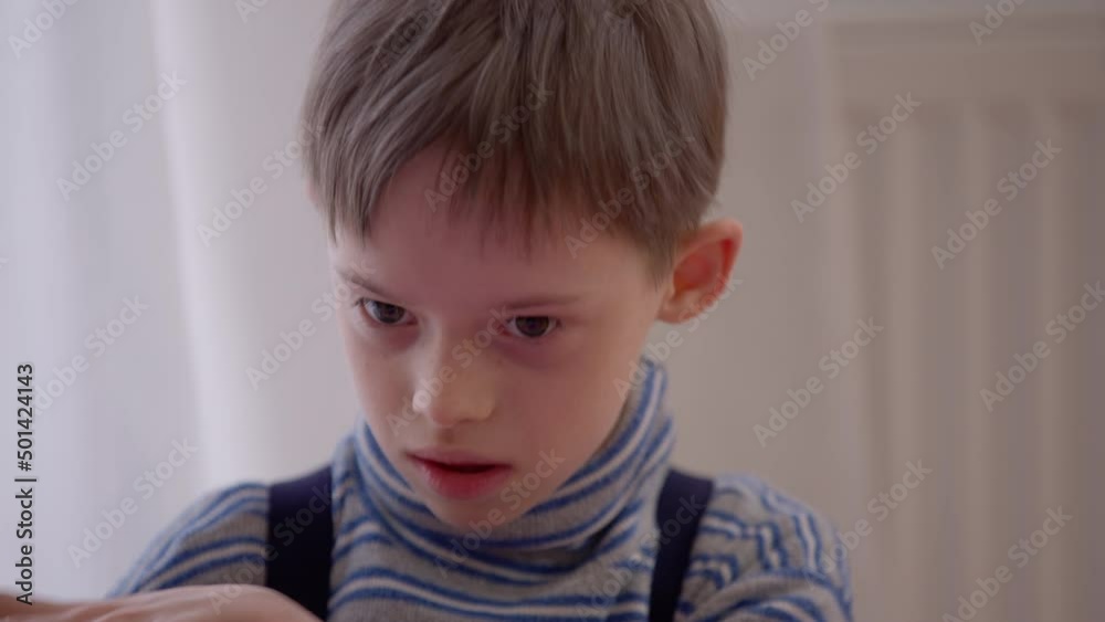 Front view close-up autistic boy get scared playing with toy indoors ...