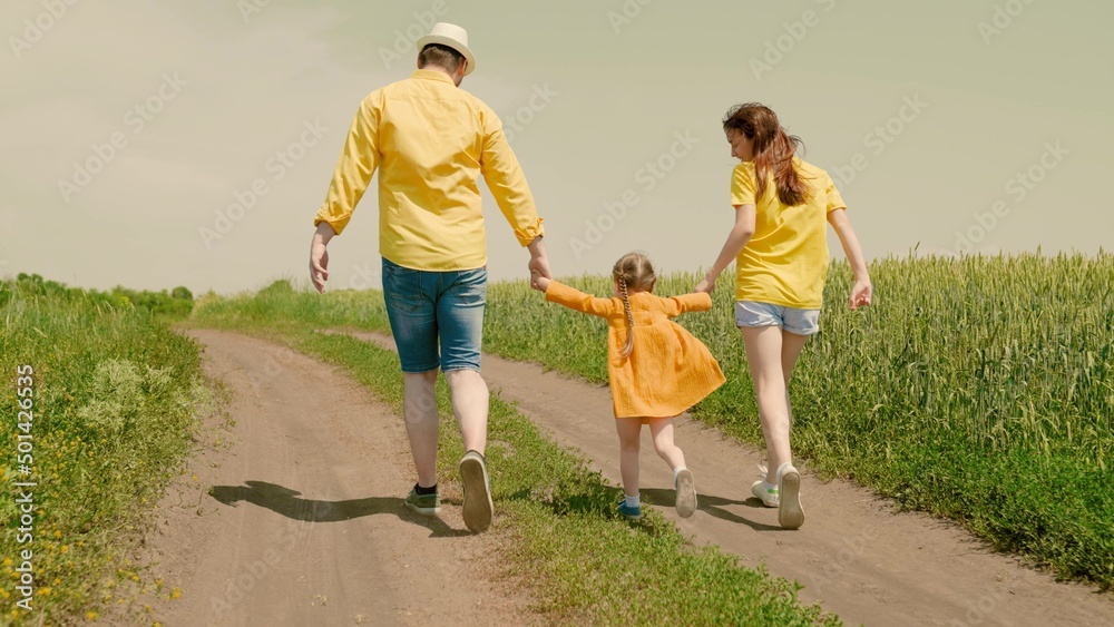 Happy family walk in afternoon in summer in field. Mom, dad, little ...