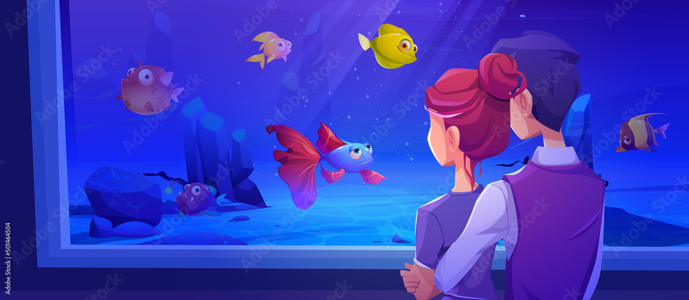 Loving couple stand front of aquarium with fishes. Young man hug woman ...
