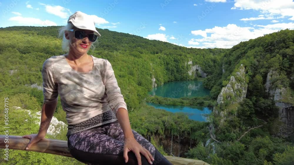 Woman sitting on overlook of Novakovica Brod Lake in the Plitvice Lakes ...