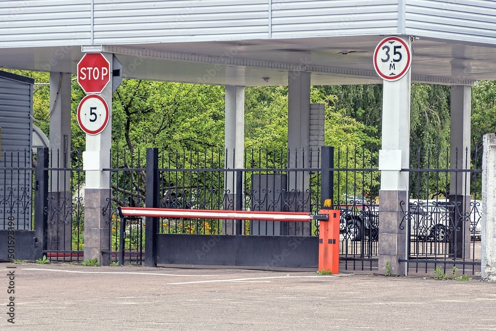 red white closed automatic barrier on the street at the checkpoint with ...