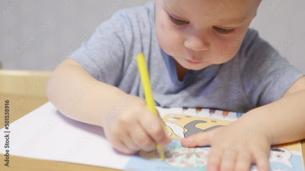 close-up portrait caucasian child kid boy drawing in coloring book ...