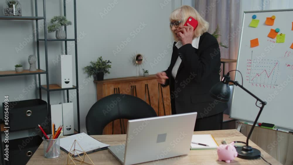 Angry senior business woman making phone call at office work place ...