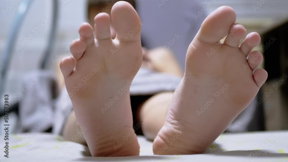 Close-up of Two Large Legs of a Sleeping Child on a Bed in a Room. The ...
