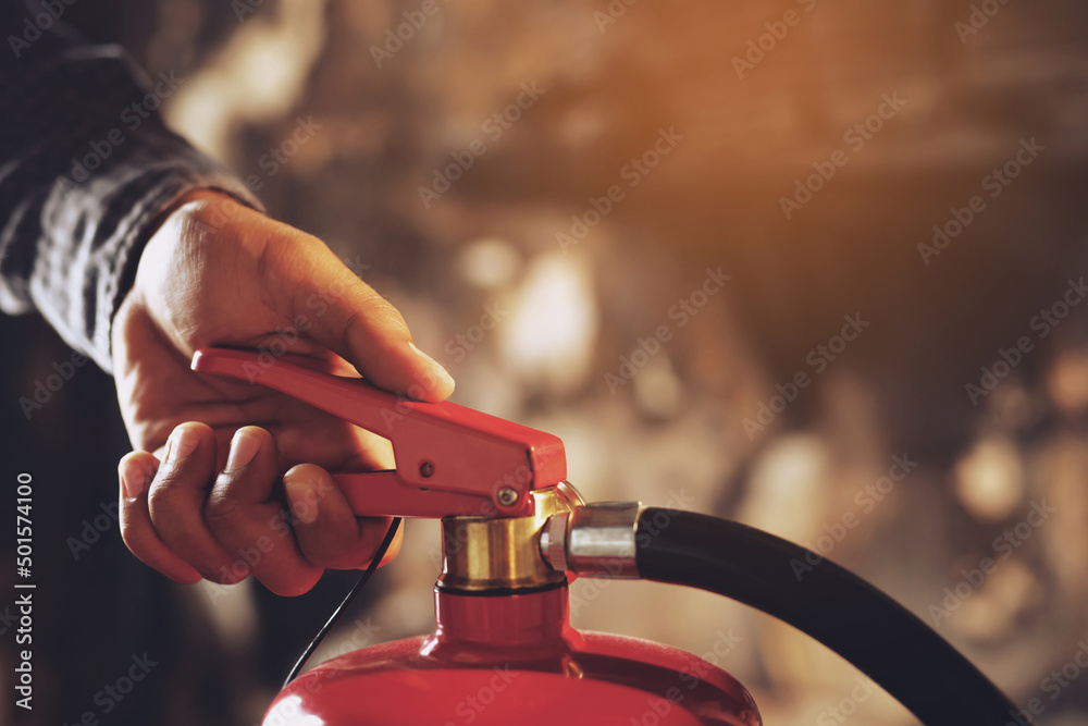 hand presses the trigger fire extinguisher available in fire ...