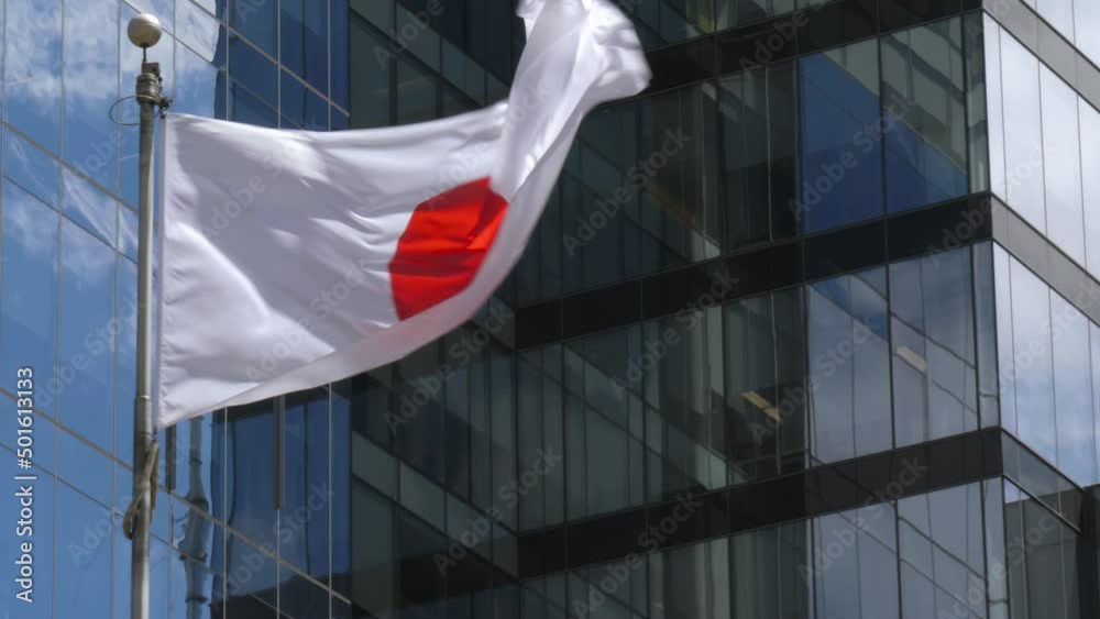 Japan national flag is waving in wind against modern building. Flag of ...