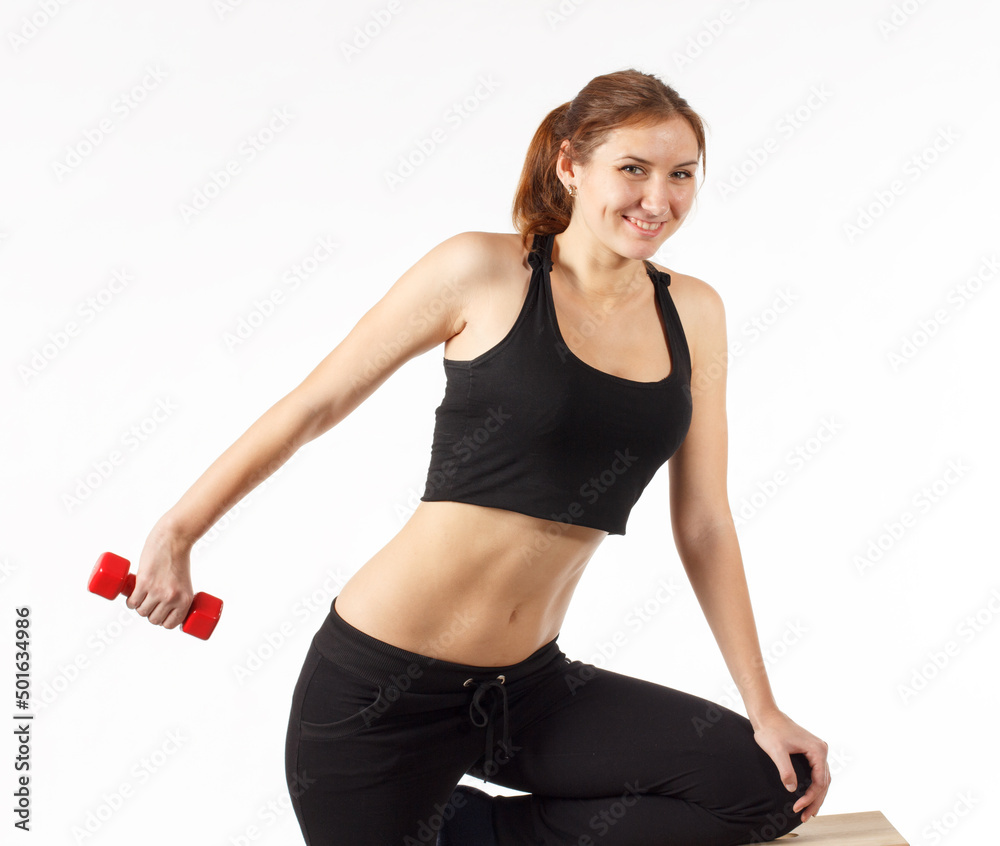 Female fitness model excercising in studio with dunbell weights and ...