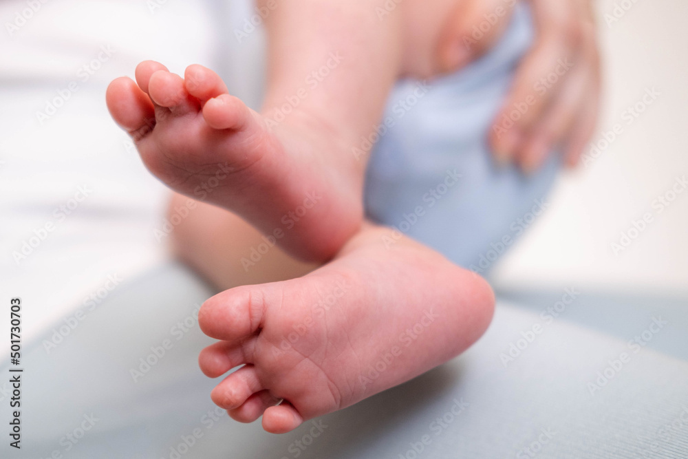 Baby legs close up, loving mother feeding her little boy child, holding ...