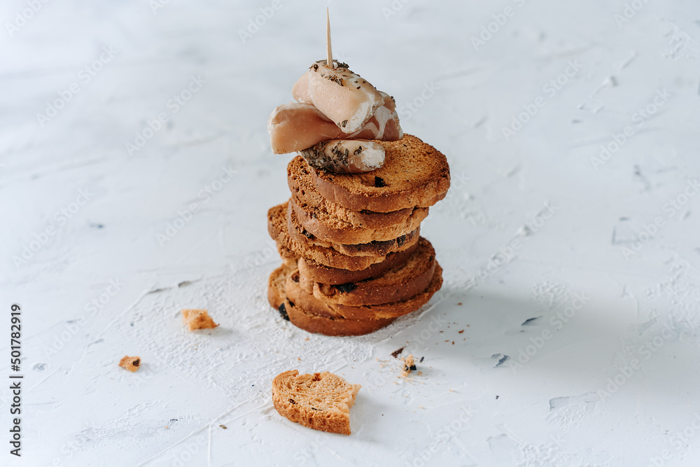 Food background. A tower of crispy toast with olives and ham and cream ...