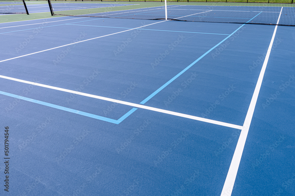 Close up photo of new outdoor blue tennis court with white lines ...