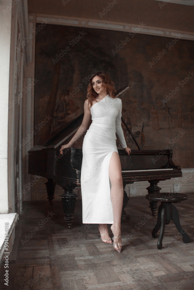 classical musician artist. young brunette girl in white slim dress ...