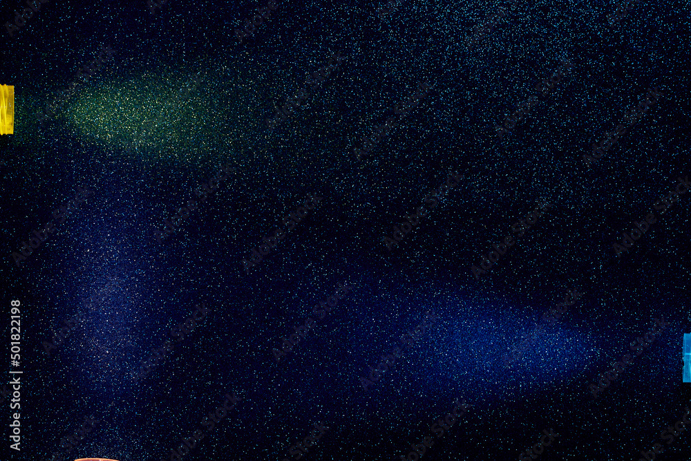 On a dark blue gradient background in fine grain, rays of violet green ...