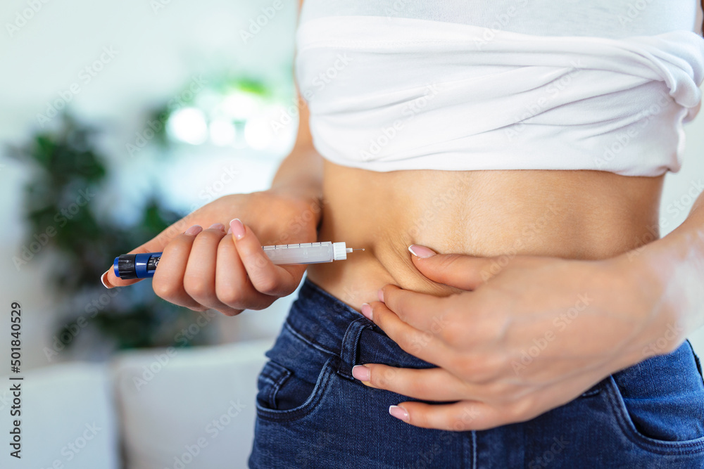 A diabetic patient using insulin pen for making an insulin injection at ...