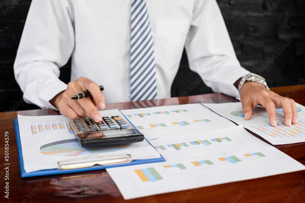 The businessman hand sits at their desks and calculates financial ...