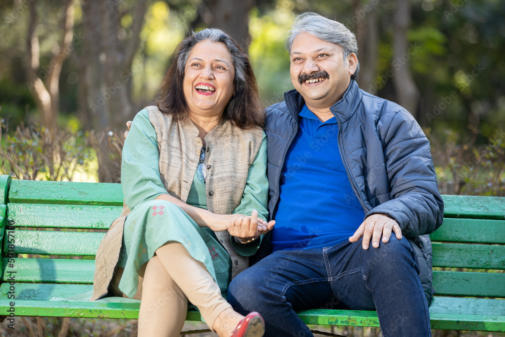 Happy Indian Or Asian Senior Couple Talking Laughing While Sitting On