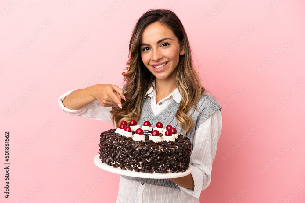 Young woman holding birthday cake over isolated pink background Stock ...