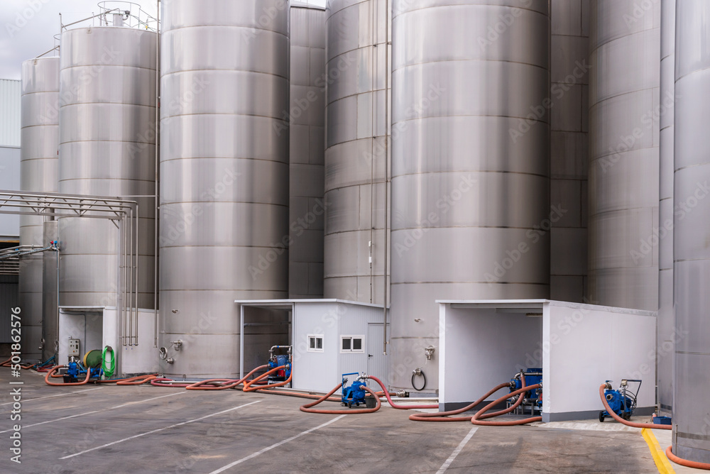 Liquid food storage tanks with pumps and hoses to load tank trucks ...