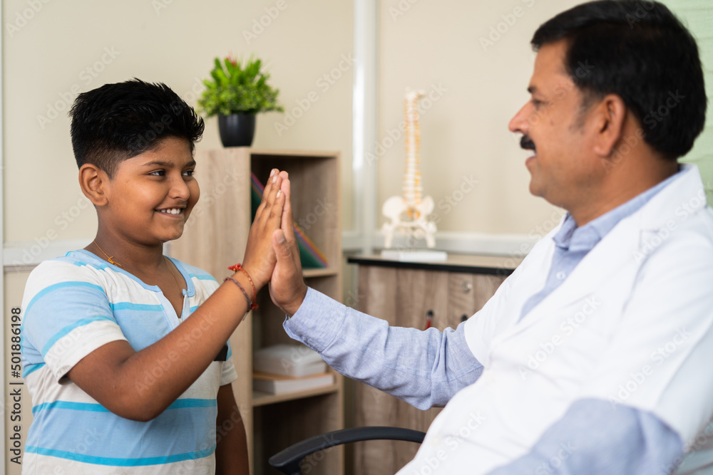 friendly doctor playing with sick child at hospital to make kid comfort ...