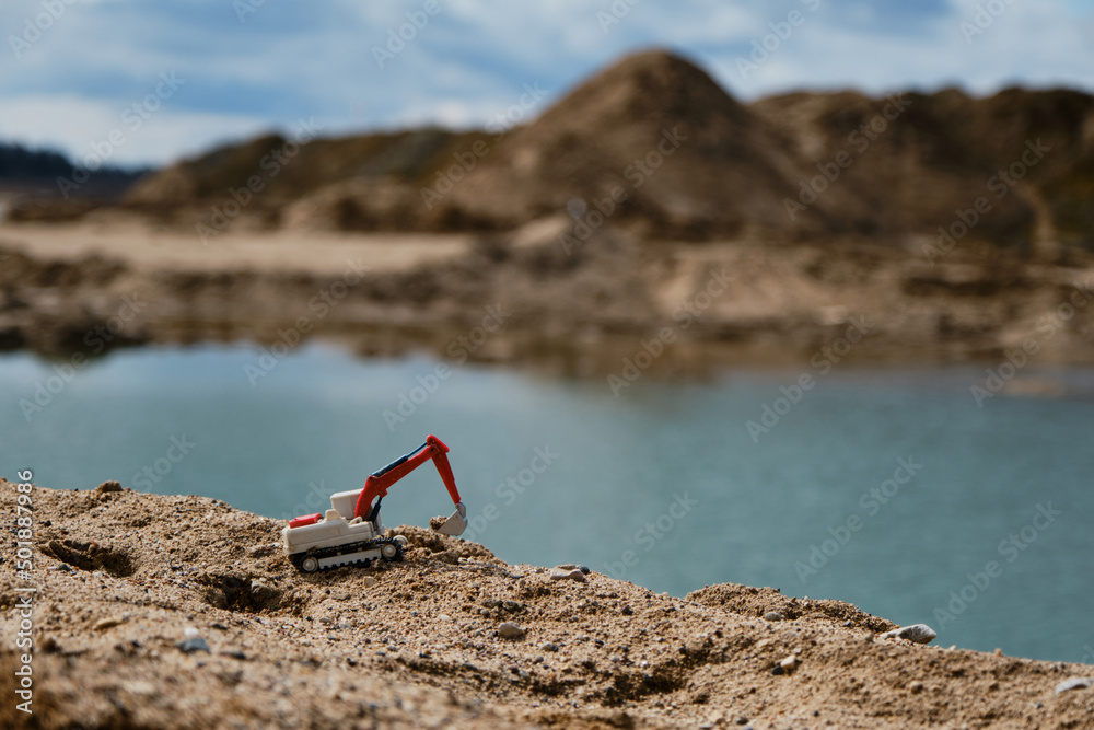 Foto Stock Small plastic toy excavator with bucket working on sand ...