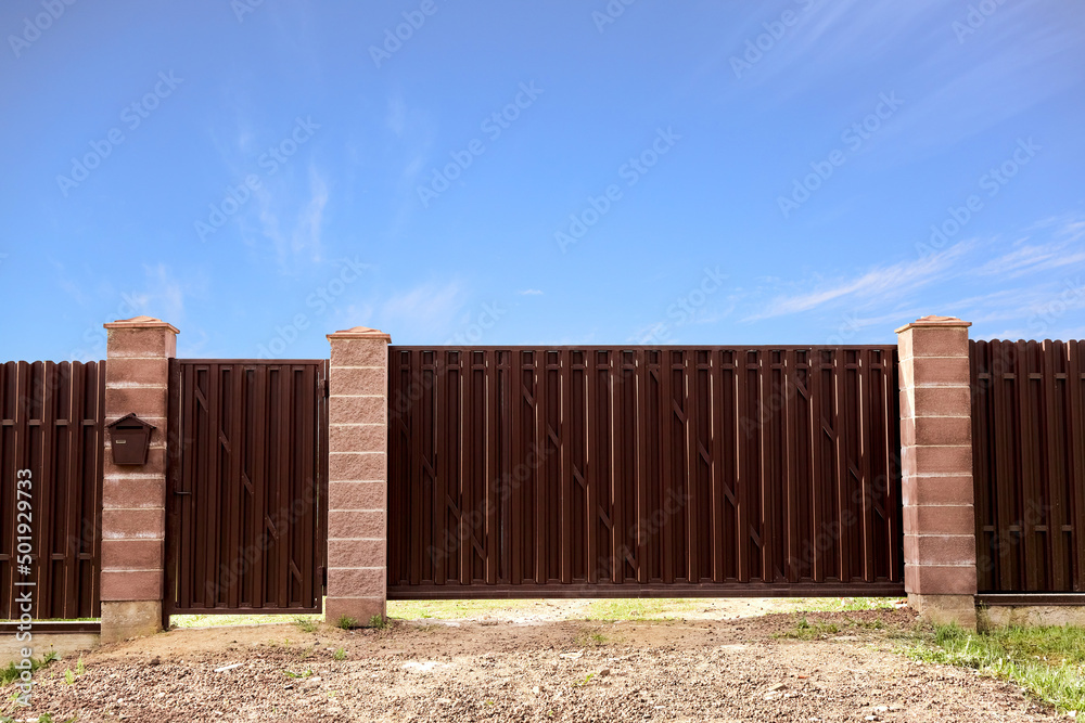 Brown metal profile fence with block posts. Entry group: gate, wicket ...