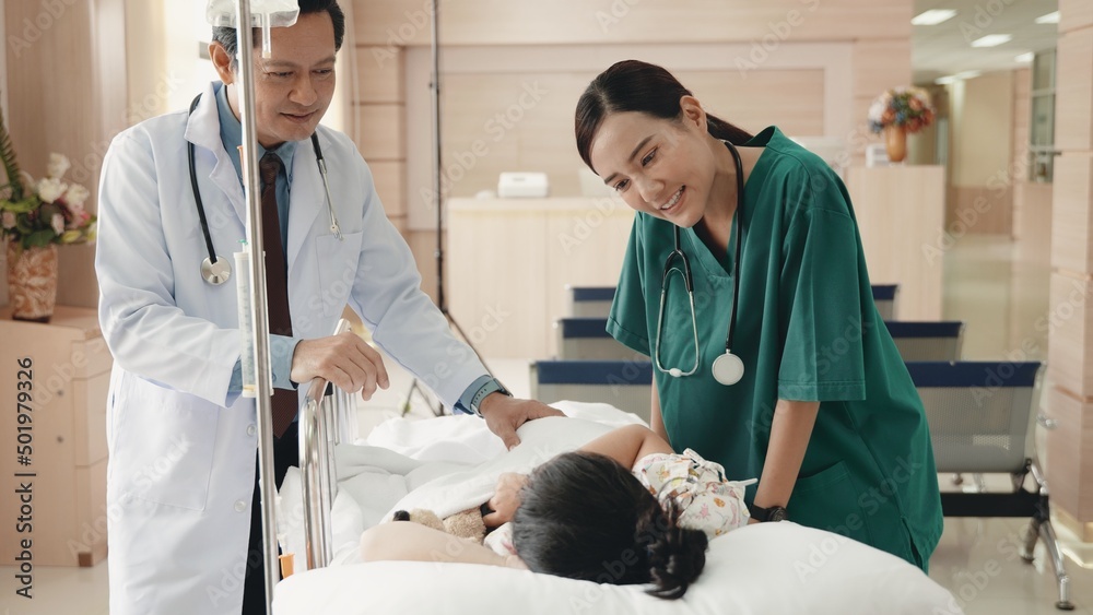 Cute little sick girl patient lying in hospital bed talking with ...