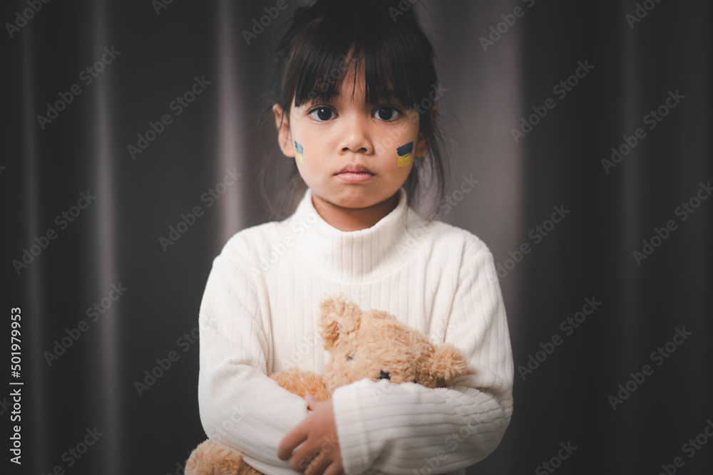 A child with the flag of Ukraine is crying. Sadness longing hope ...