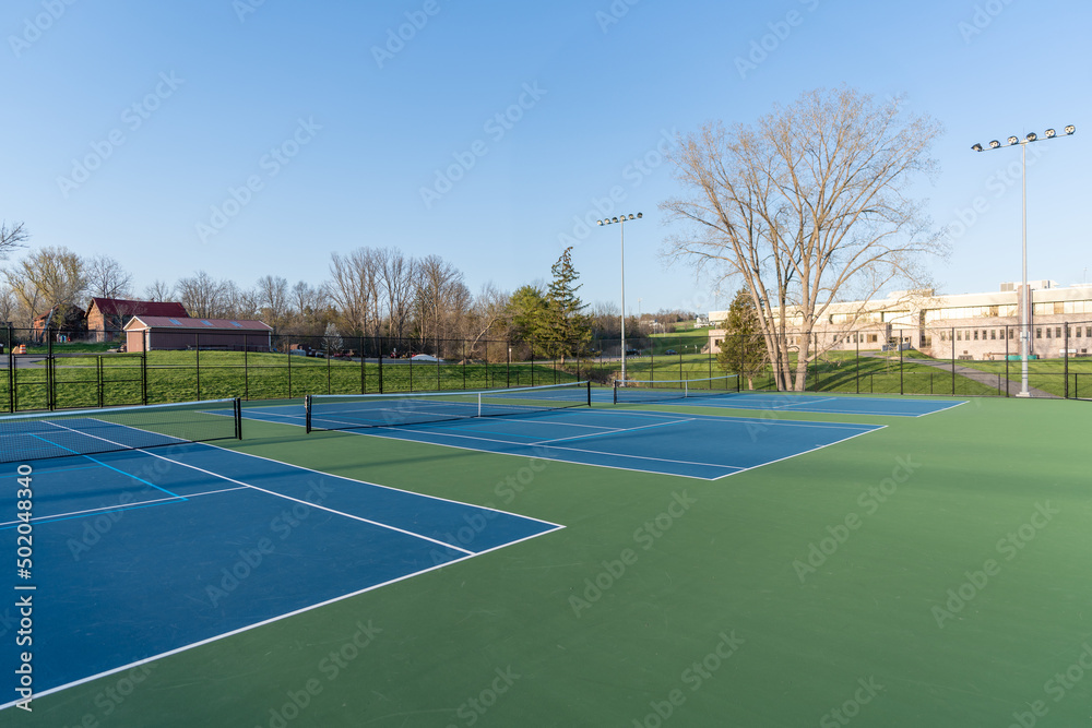 Blue tennis courts with white lines and light blue pickleball lines ...