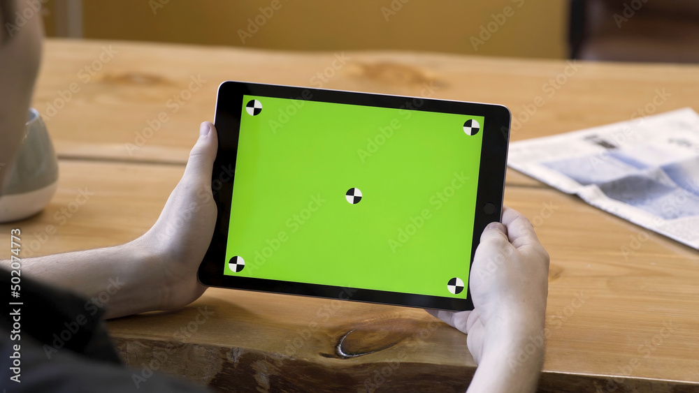 Foto de Young guy holding the tablet with touching green screen with ...