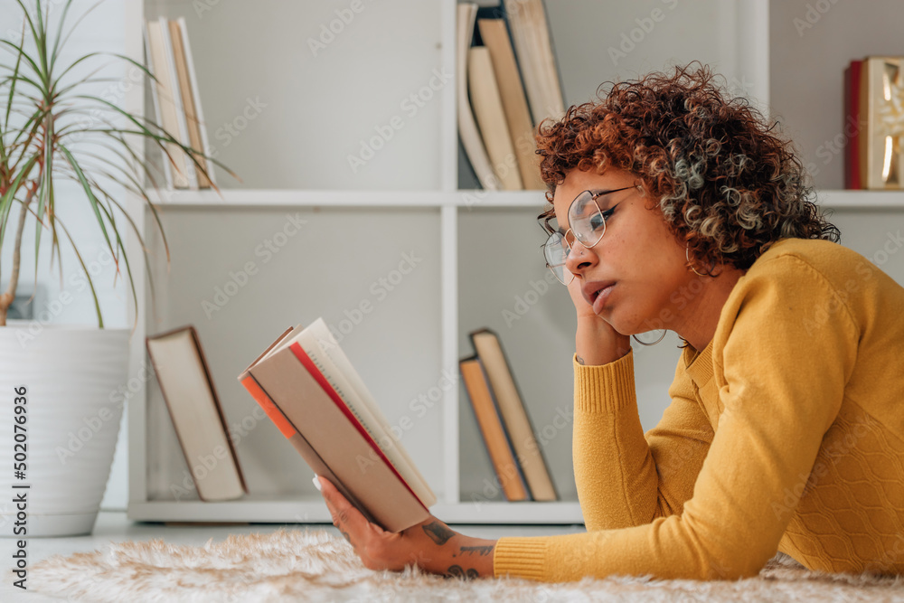 girl at home relaxed reading a textbook Stock Photo | Adobe Stock