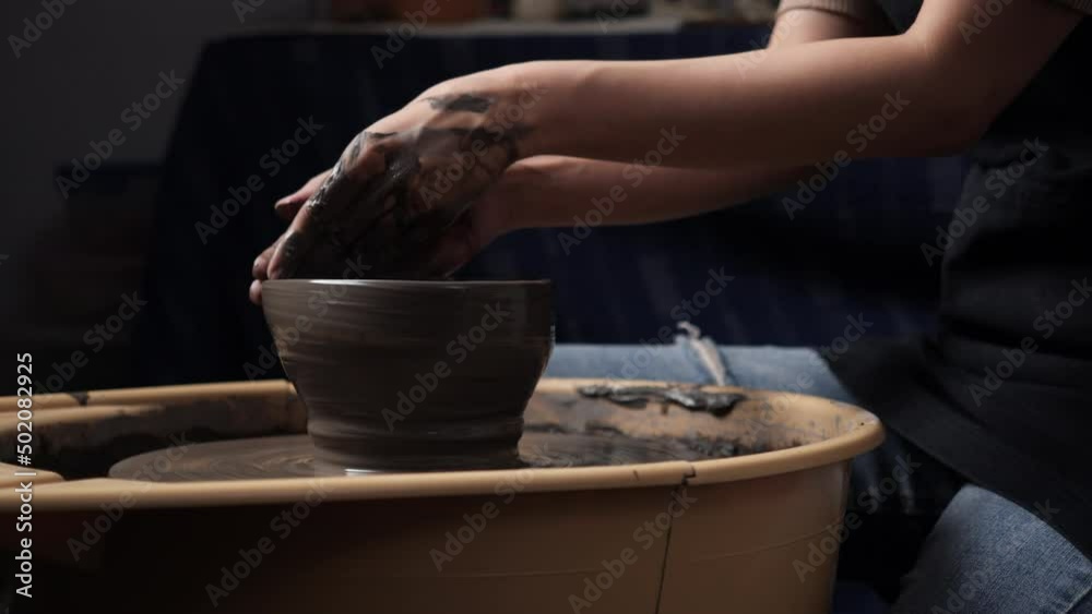 Anonymous people using pottery wheel and sculpting clay in pottery ...