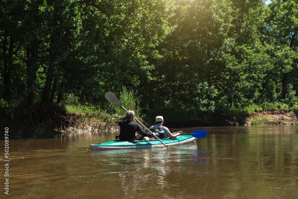 Family kayak trip. An elderly married couple rowing a boat on the river ...