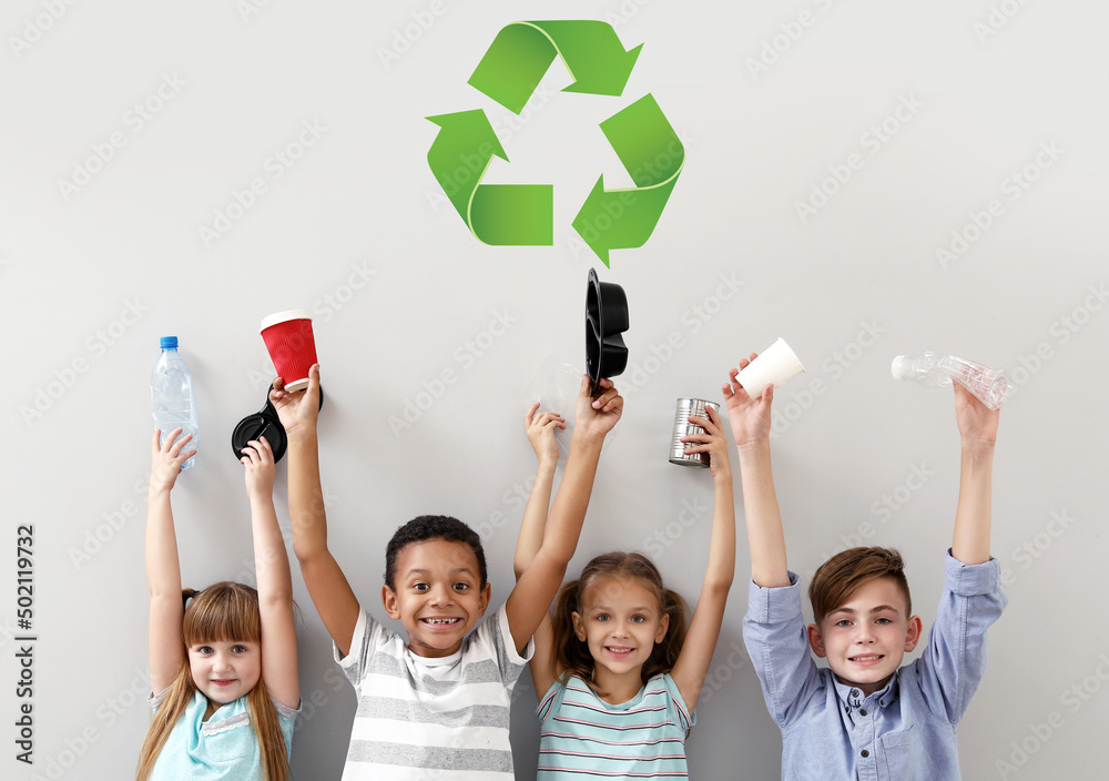 Little children with different trash and symbol of recycling on light ...