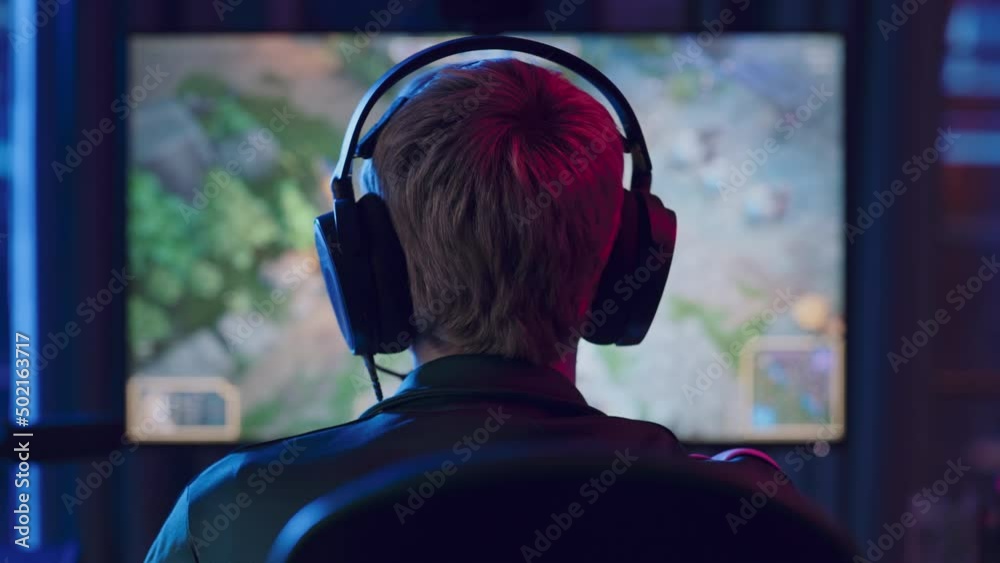 Back of the Head Angle of a Young Female Gamer Putting on Headphones ...