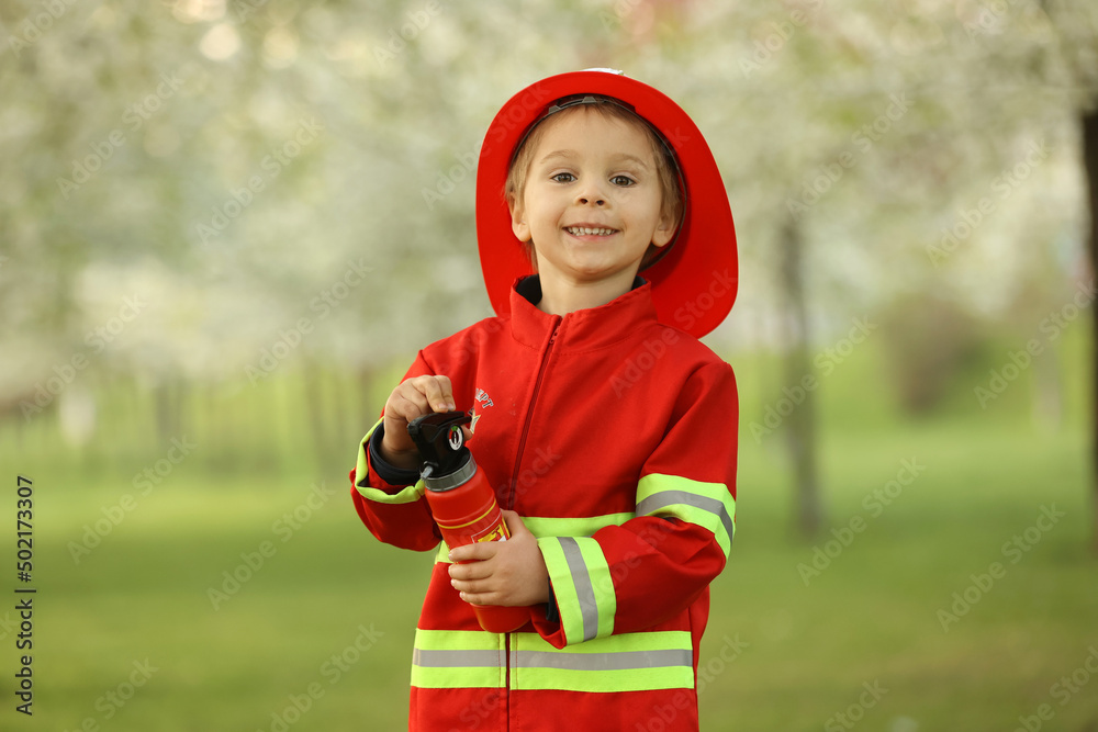 Little toddler child with fireman costume in park, pretending to be ...